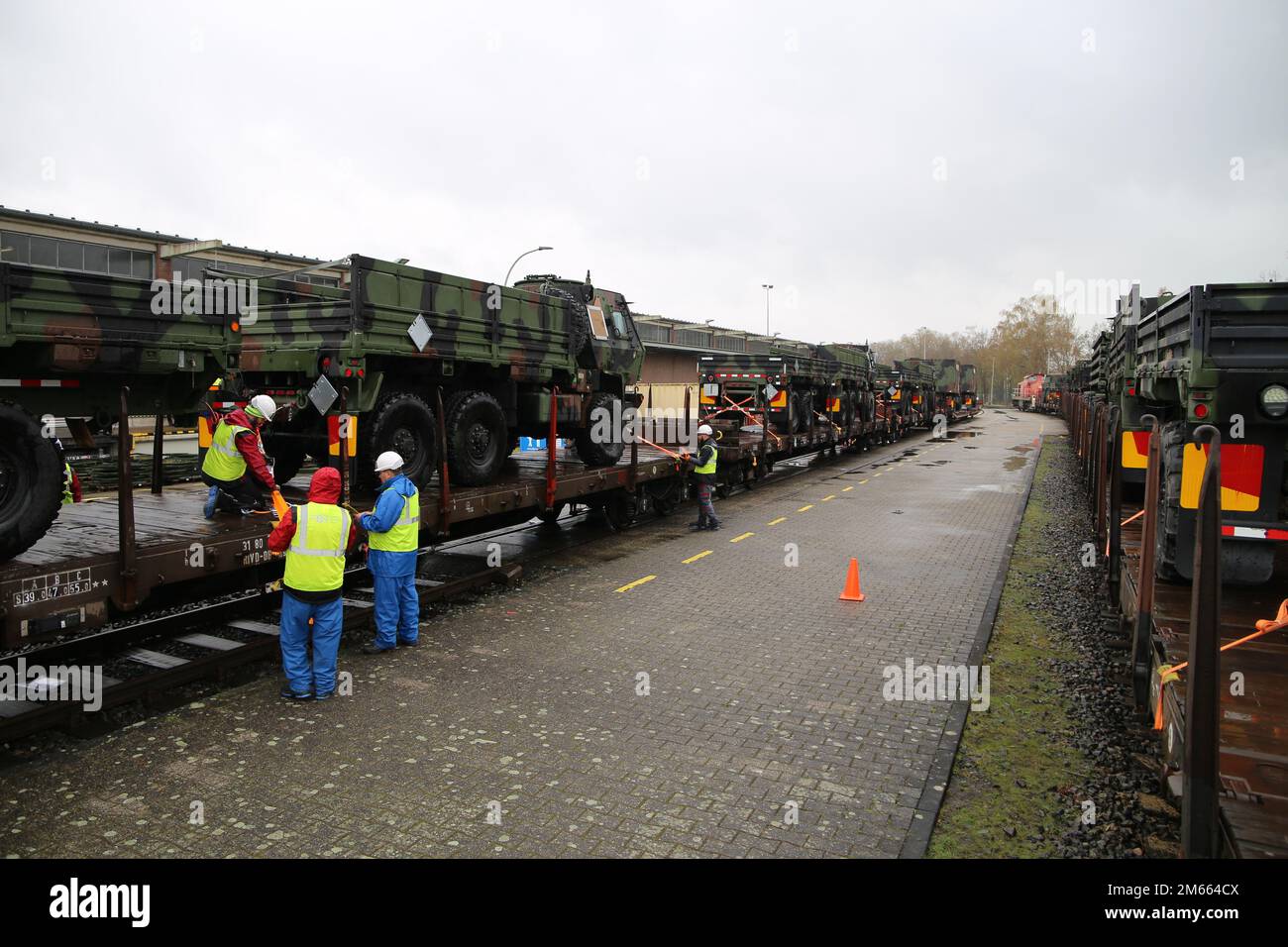 Contractors help load rail cars shipping out materiel in preparation ...
