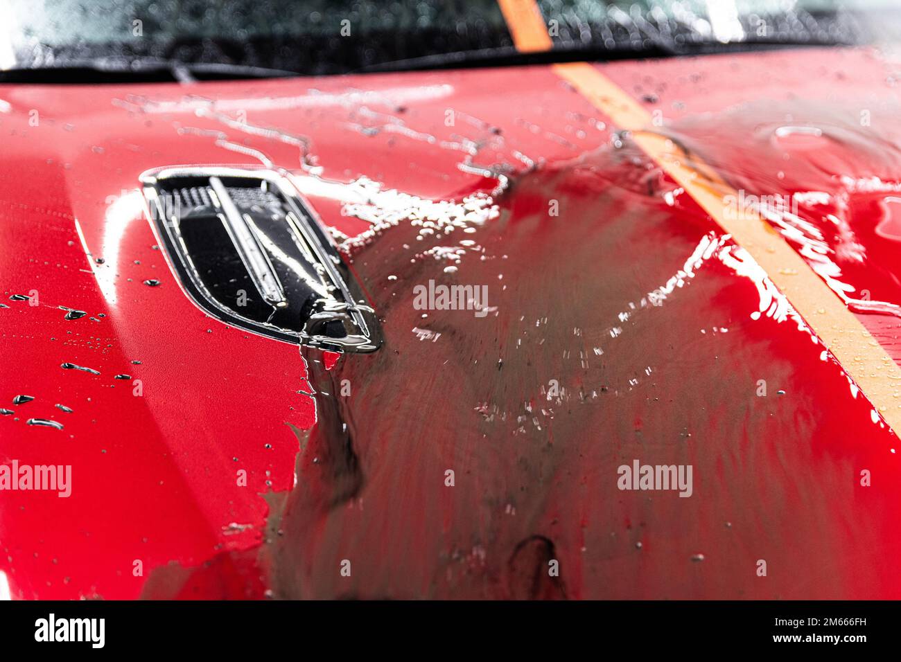 Rinsing dirt from the paint of a red car Stock Photo - Alamy