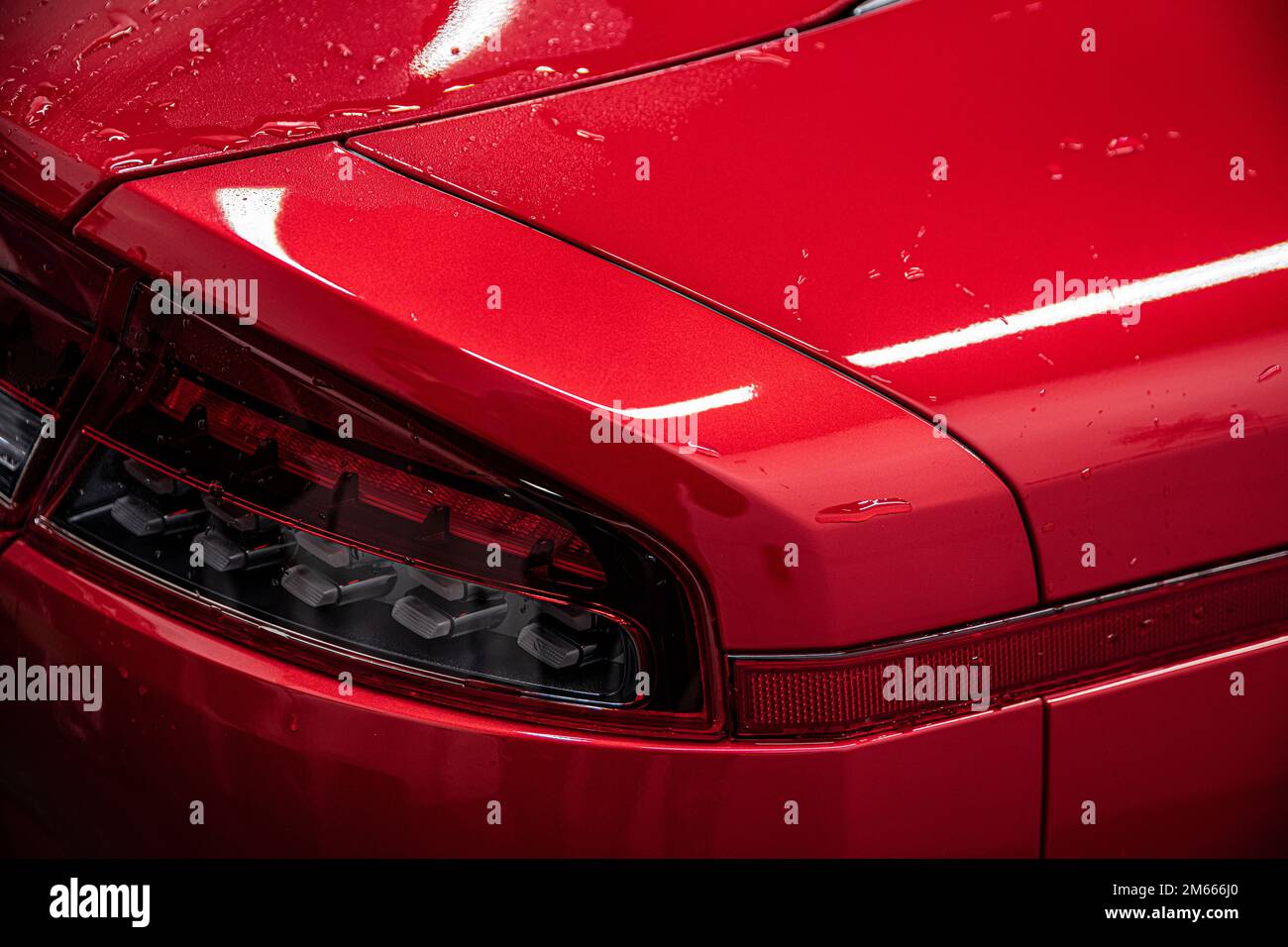 Glossy paint of a red car - rear lamp and corner Stock Photo - Alamy