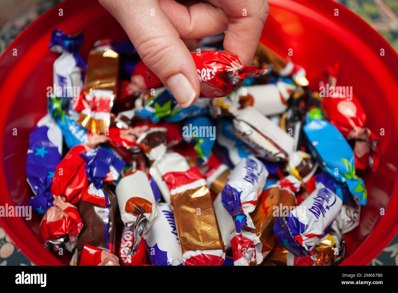 Hand reaching in Celebrations chocolate box Stock Photo - Alamy