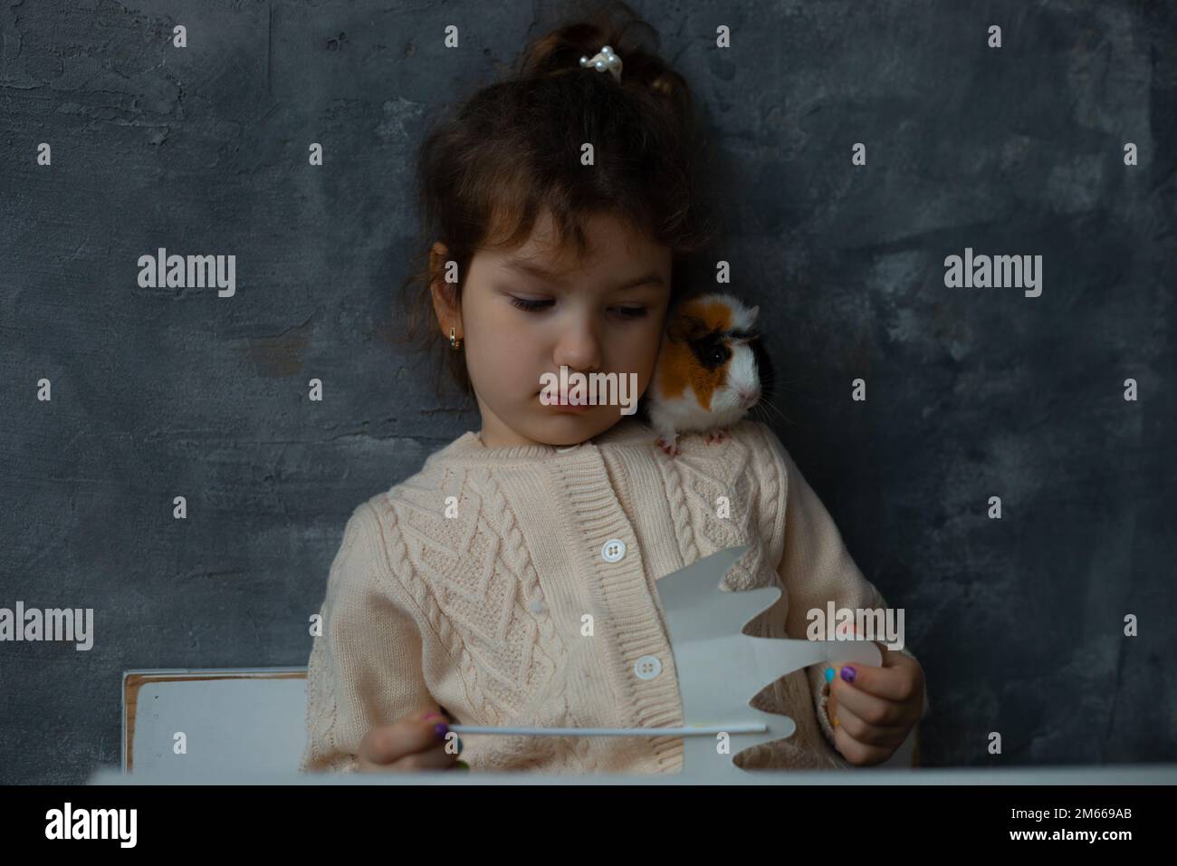 Calm, quiet, serious, lonely little girl with guinea pig on shoulder ... Calm, quiet, serious, lonely little girl with guinea pig on shoulder ...