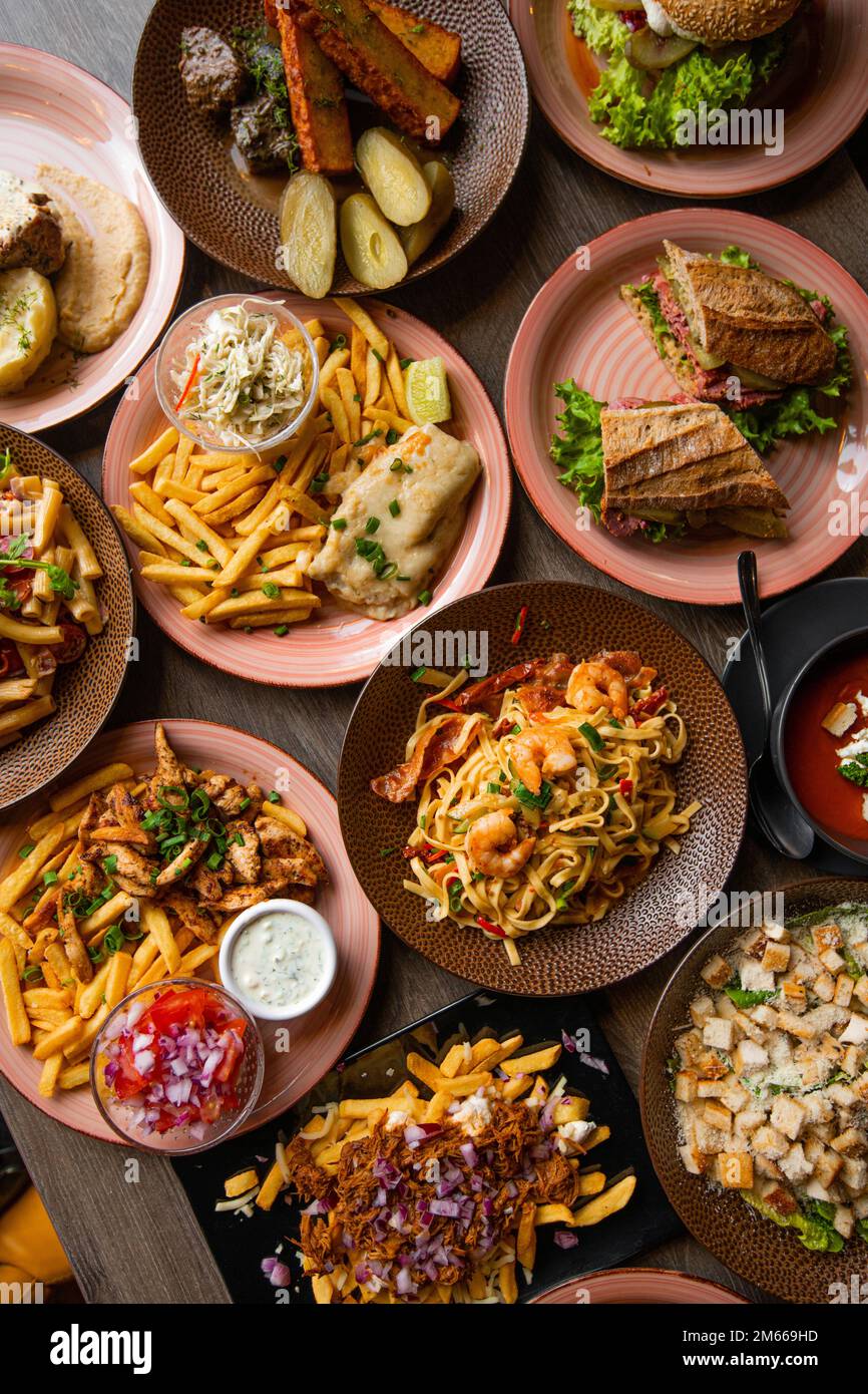 Vertical photo various of food on cafe table. Italian, american food ...