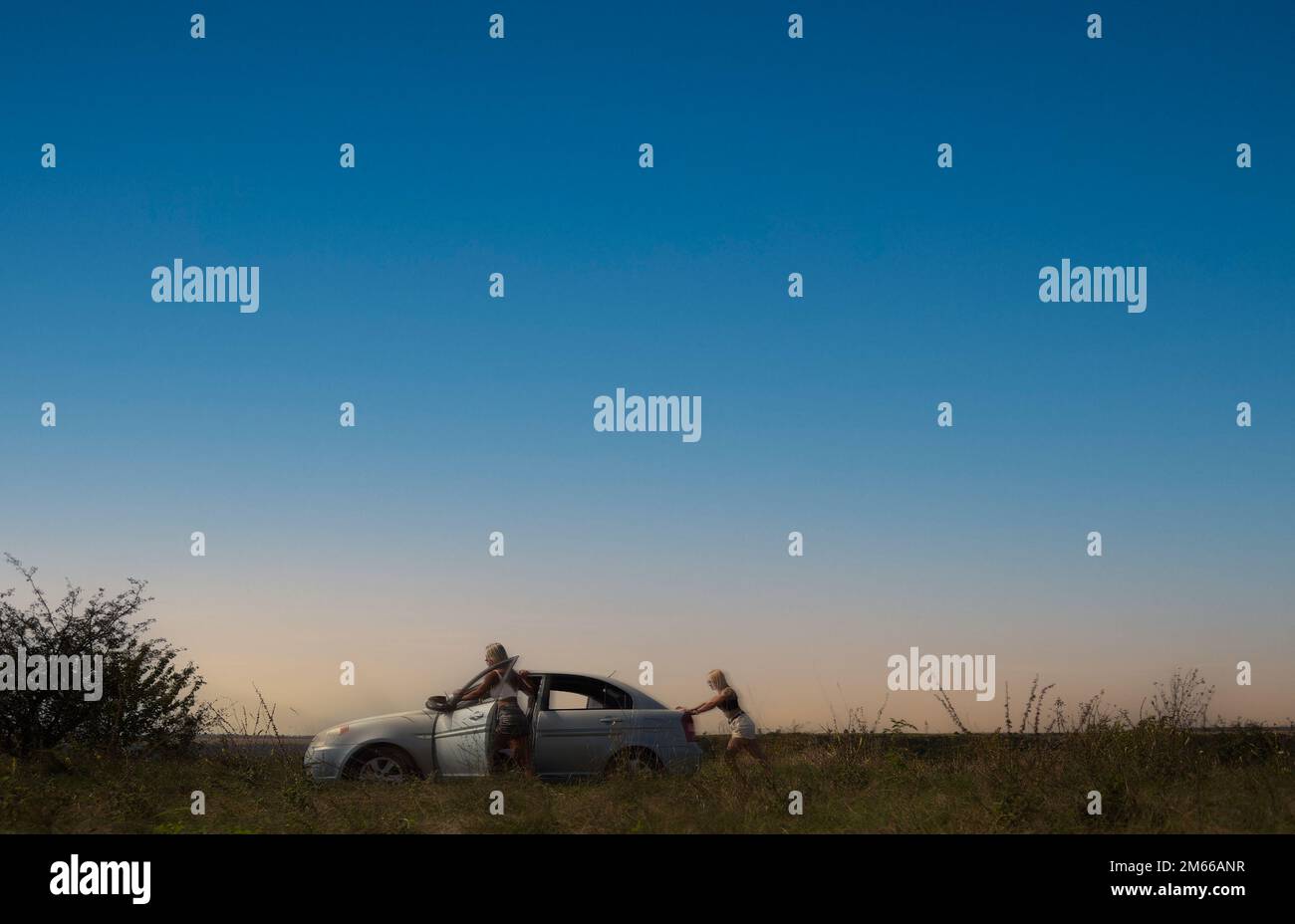 an accident on the road, a car broke down, two beautiful girl models ...