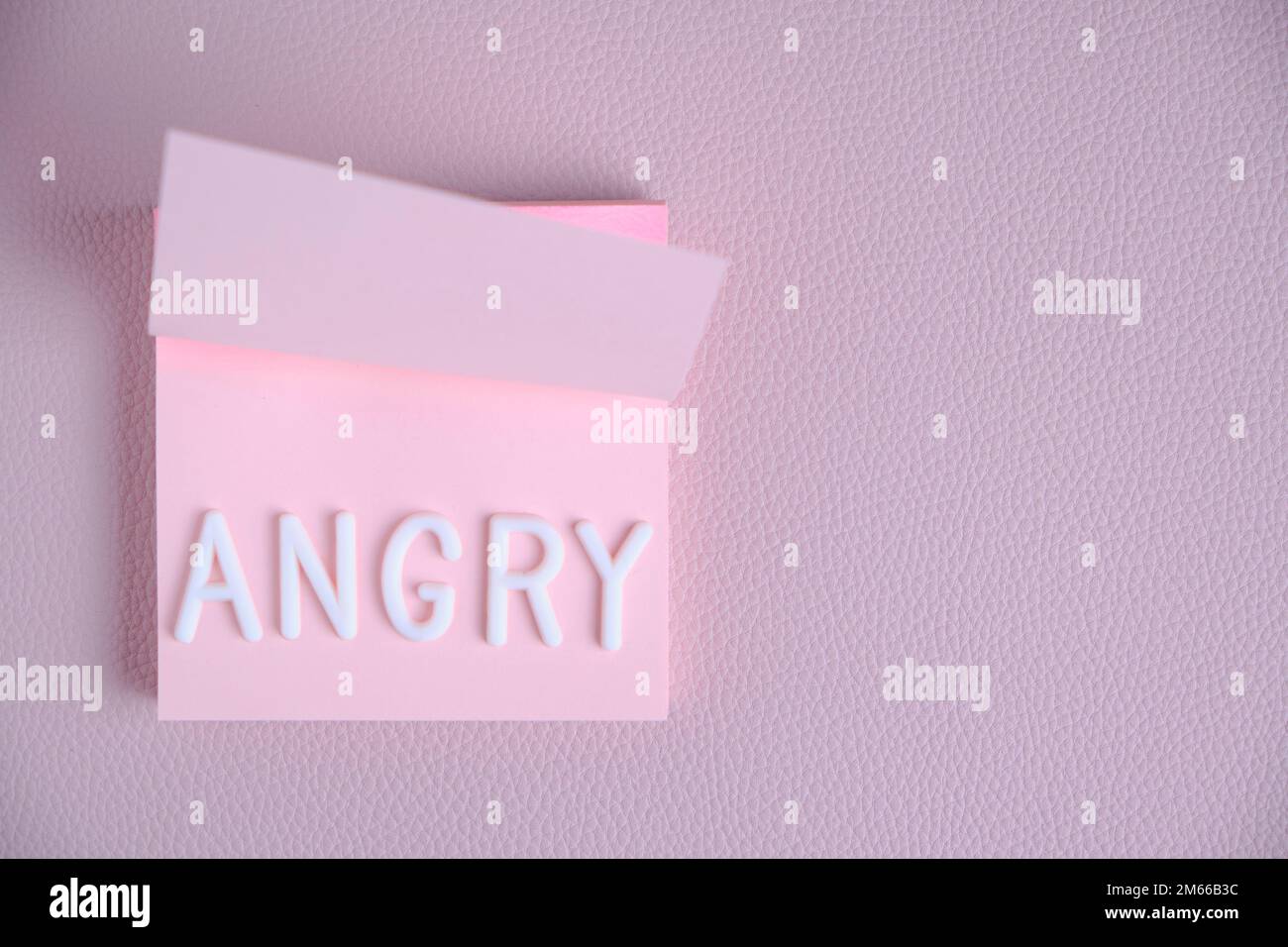 Word angry laid out white letters pink piece paper.Concept of anger ...