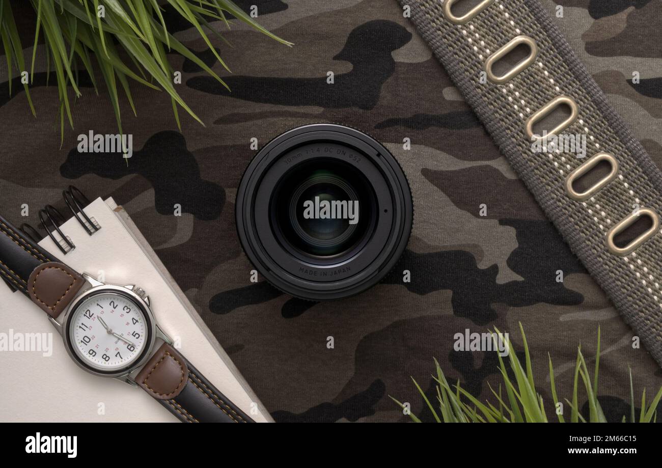 Overhead flat lay of a 30mm f1.4 camera lens surrounded by personal ...