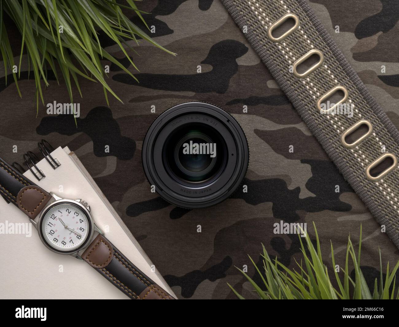 Overhead flat lay of a 30mm f1.4 camera lens surrounded by personal ...