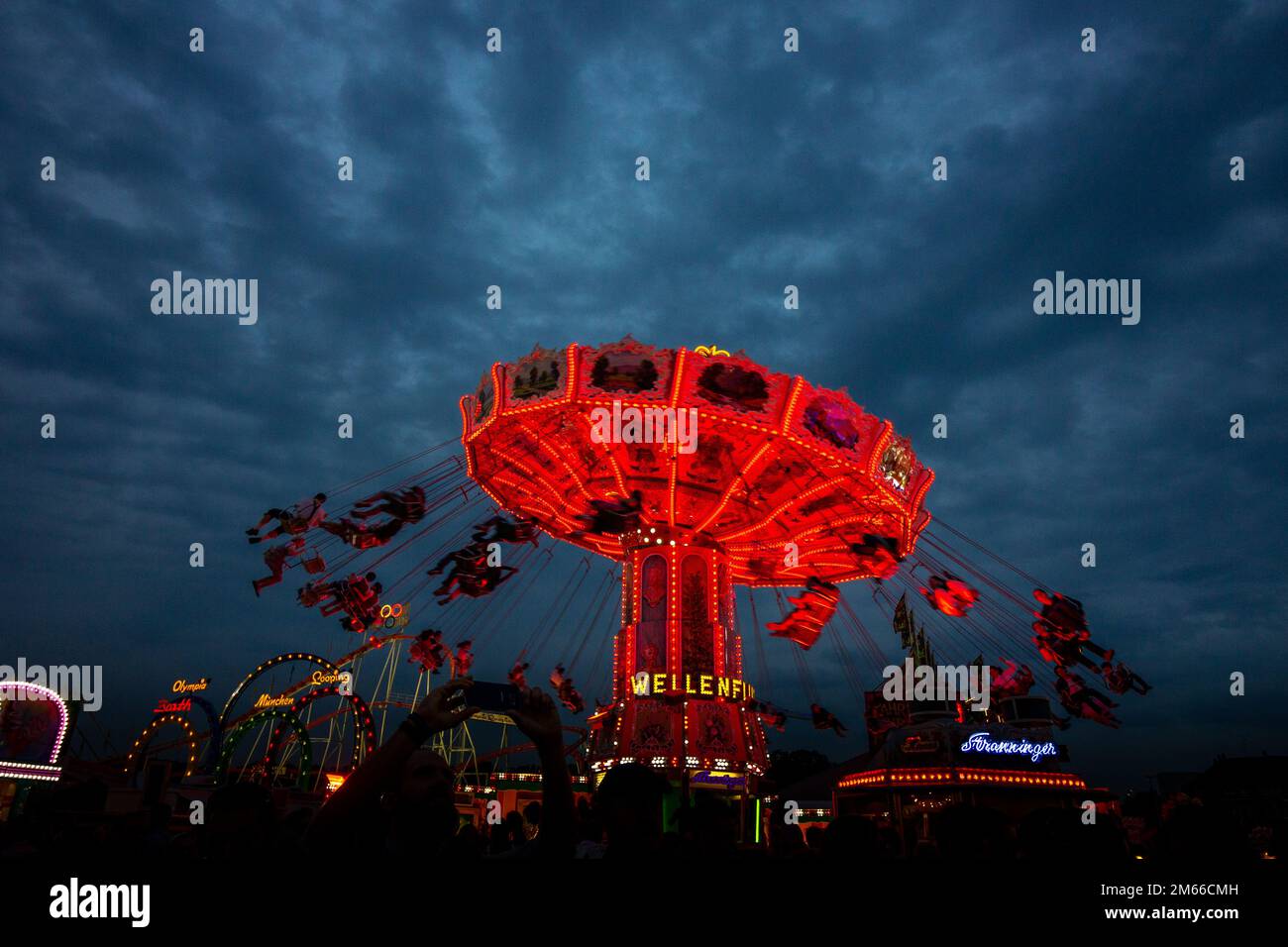 Mechanical game, flying chairs in Oktoberfest festival at night in ...