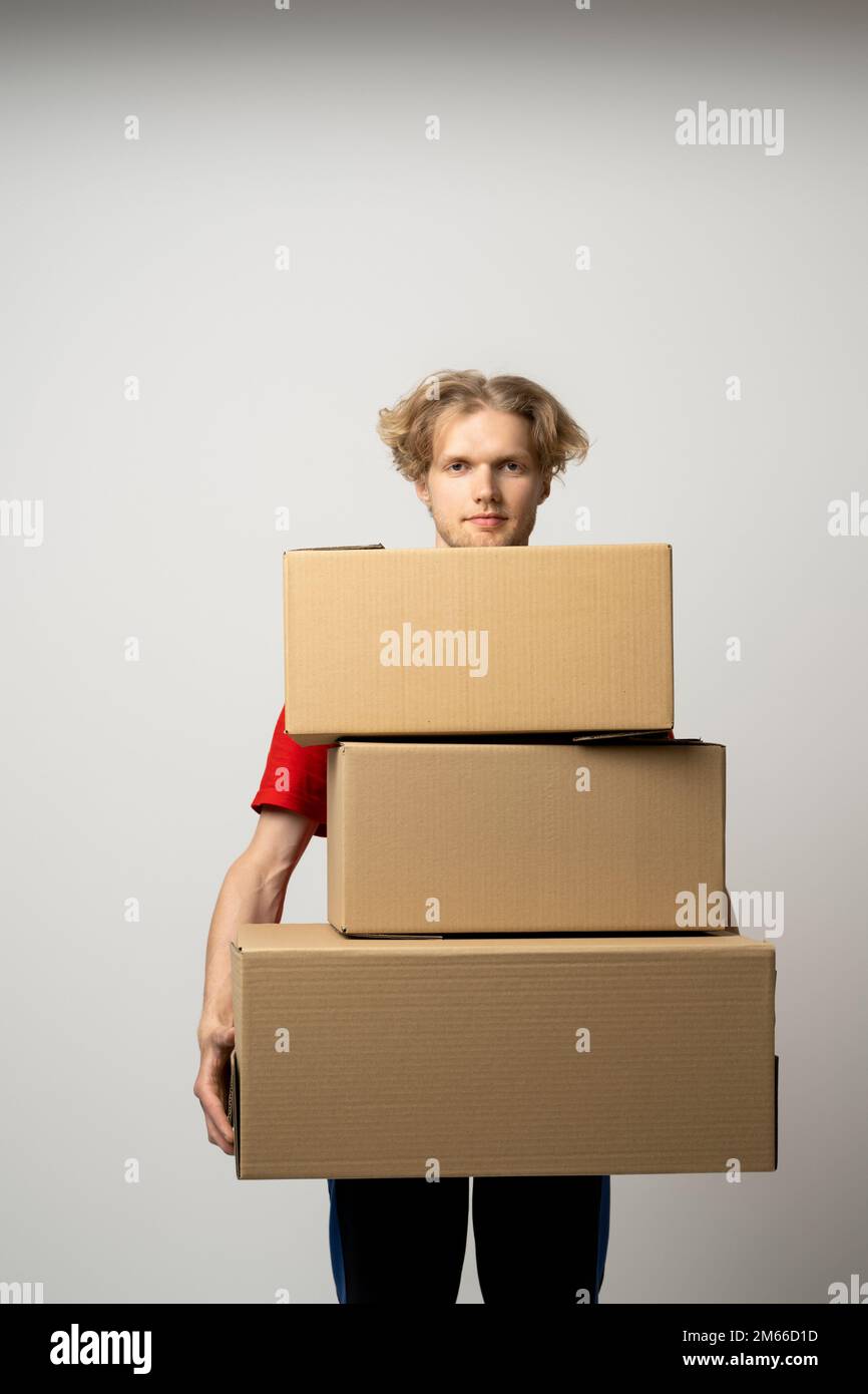 Delivery man in red uniform hold blank cardboard, percel isolated on ...