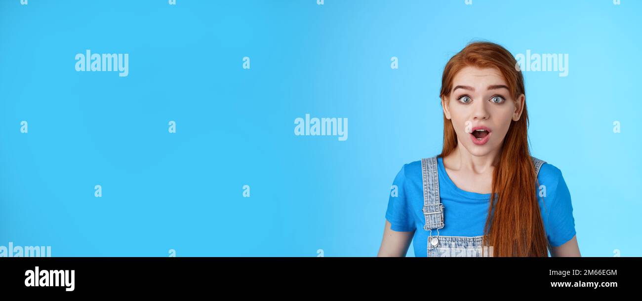 Shocked redhead girl react omg shook, drop jaw speechless, stare ...