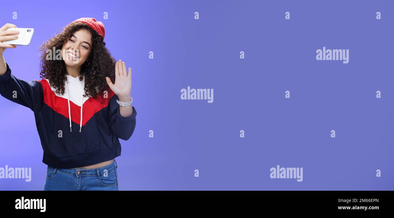 Studio shto of stylish cute female vlogger with curly hair in winter ...