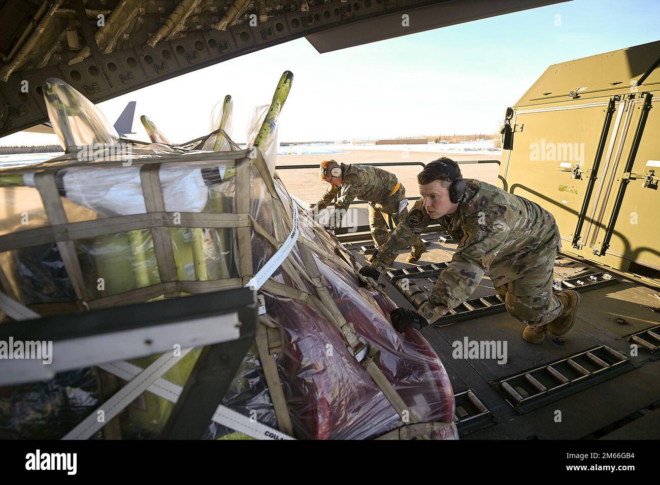 U.S. Air Force aerial porters prepare to load cargo onto a C-17 ...