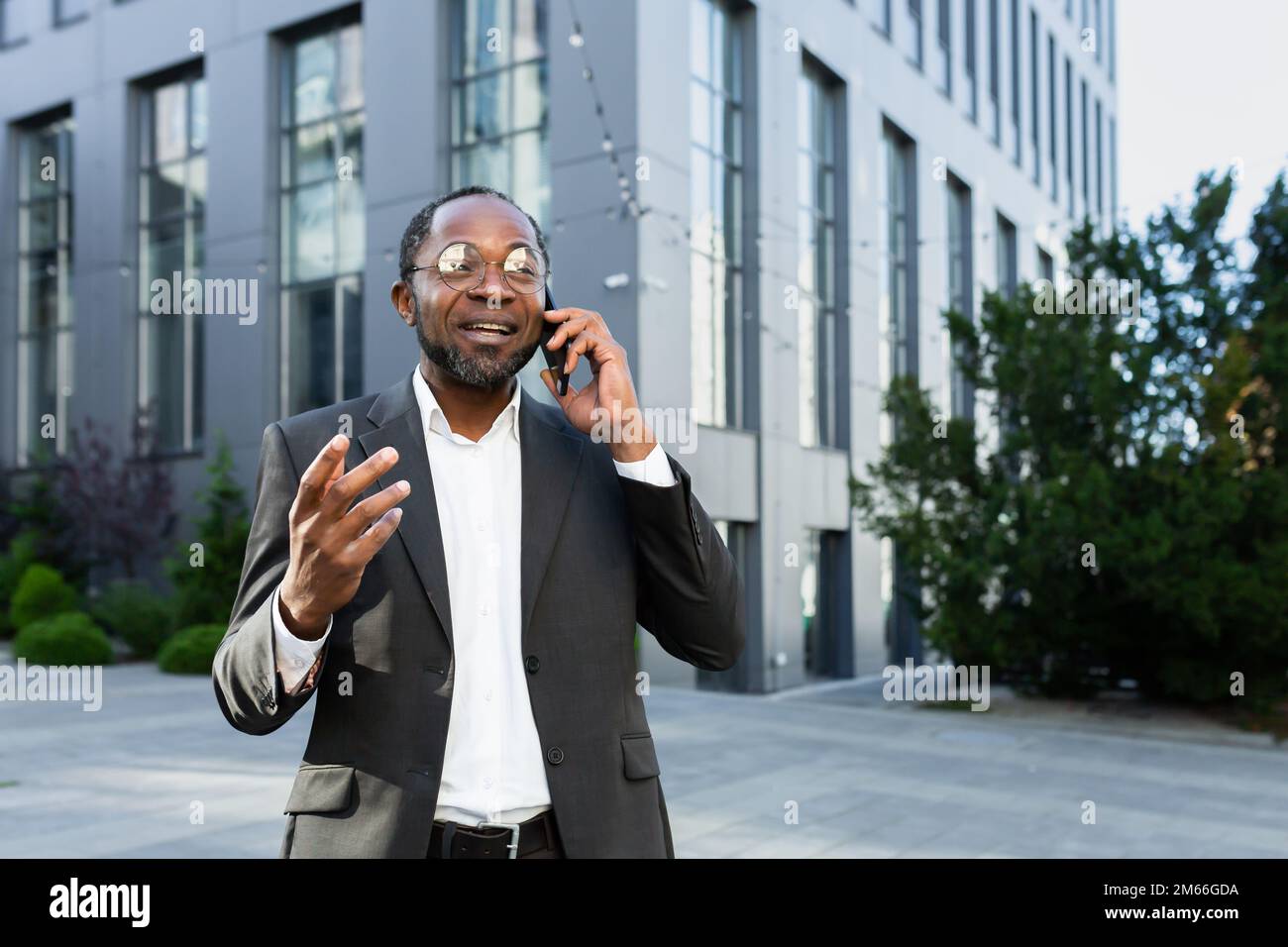 Cheerful and satisfied african american boss outside office building ...