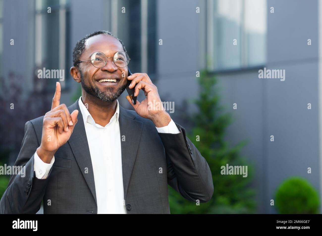 Cheerful and satisfied african american boss outside office building ...