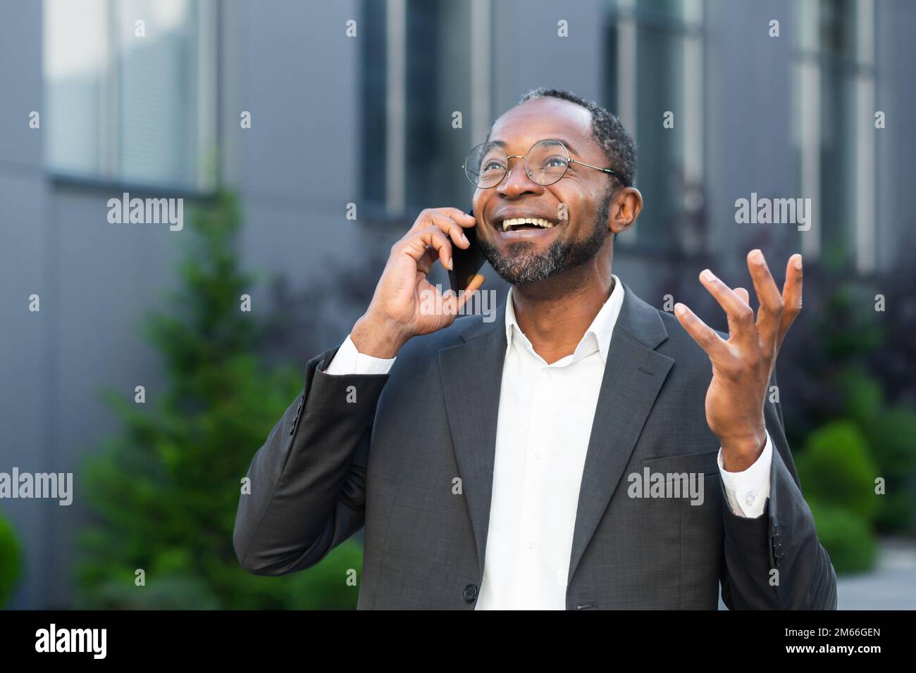 Cheerful and satisfied african american boss outside office building ...