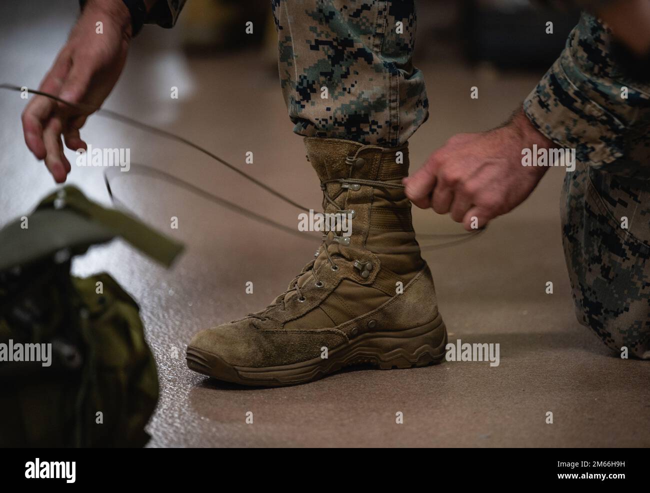 A U.S. Marine ties his boot laces before the Norwegian Foot March April ...
