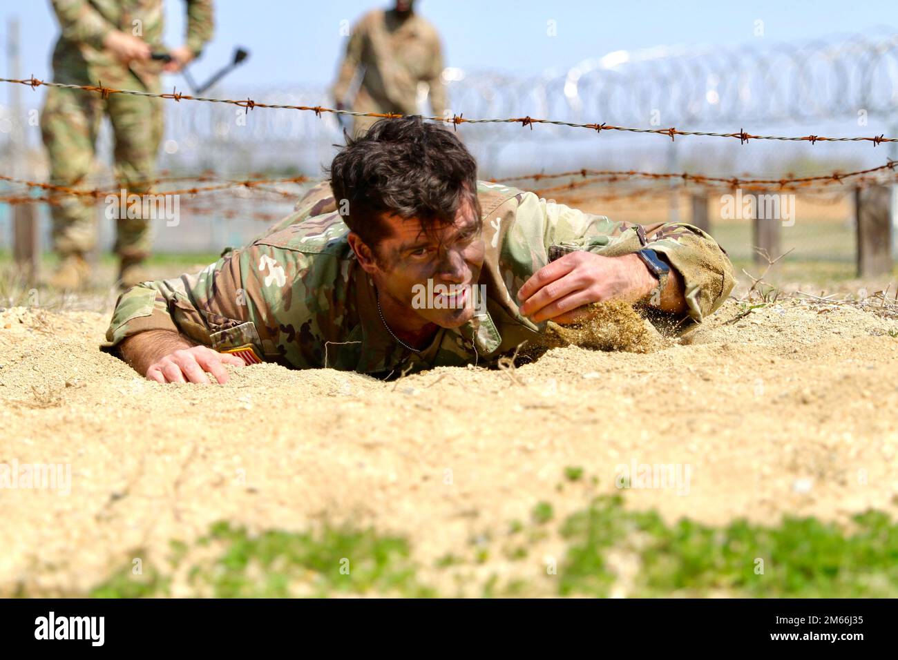 1st. Lt. William Hacker crawls under barbed wire at the Camp Humphreys ...