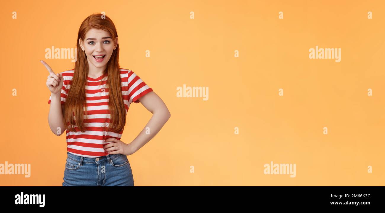 Lively friendly redhead woman discuss new trend pointing upper left ...