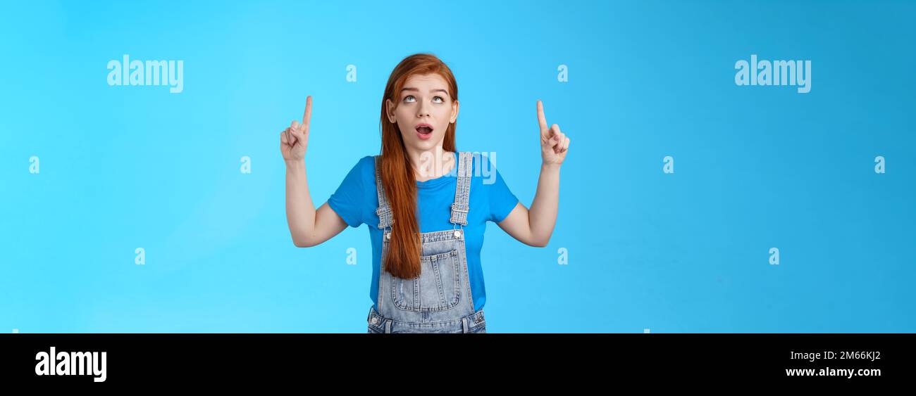 Studio shot amazed curious redhead woman drop jaw astonished, look ...