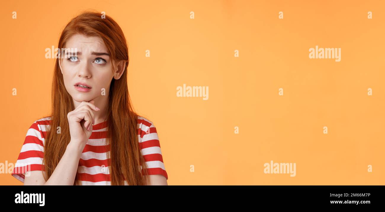 Perplexed redhead woman trying make calculations mind, frowning focused ...