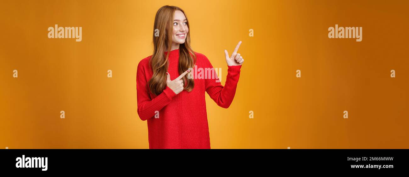 Interested gentle and tender young 20s ginger woman in red warm sweater ...