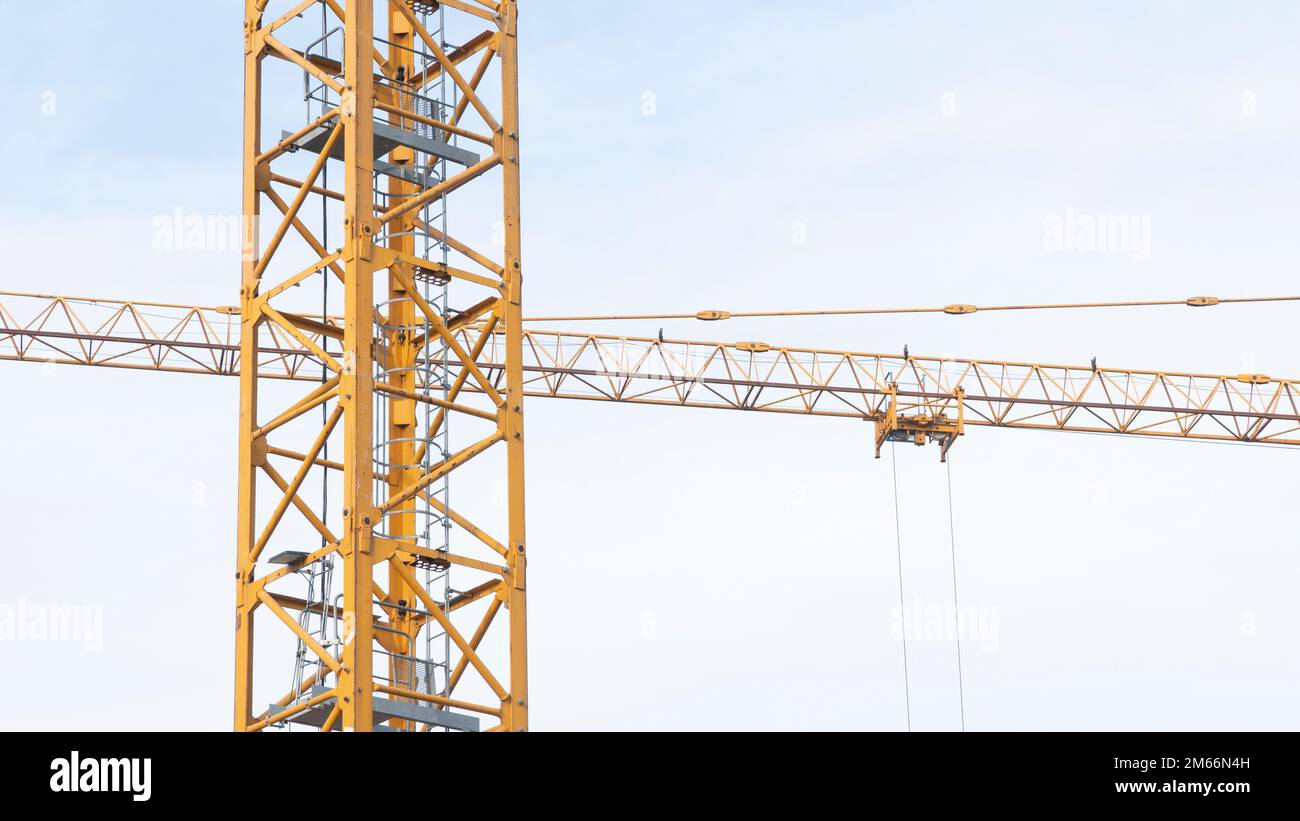 Low-angle view of a construction crane at work on a building site. High ...