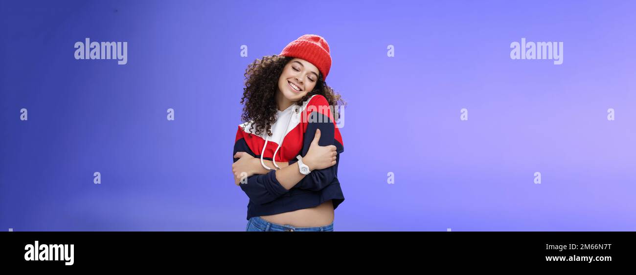 Sweet tender and sensual curly-haired woman in red stylish beanie ...