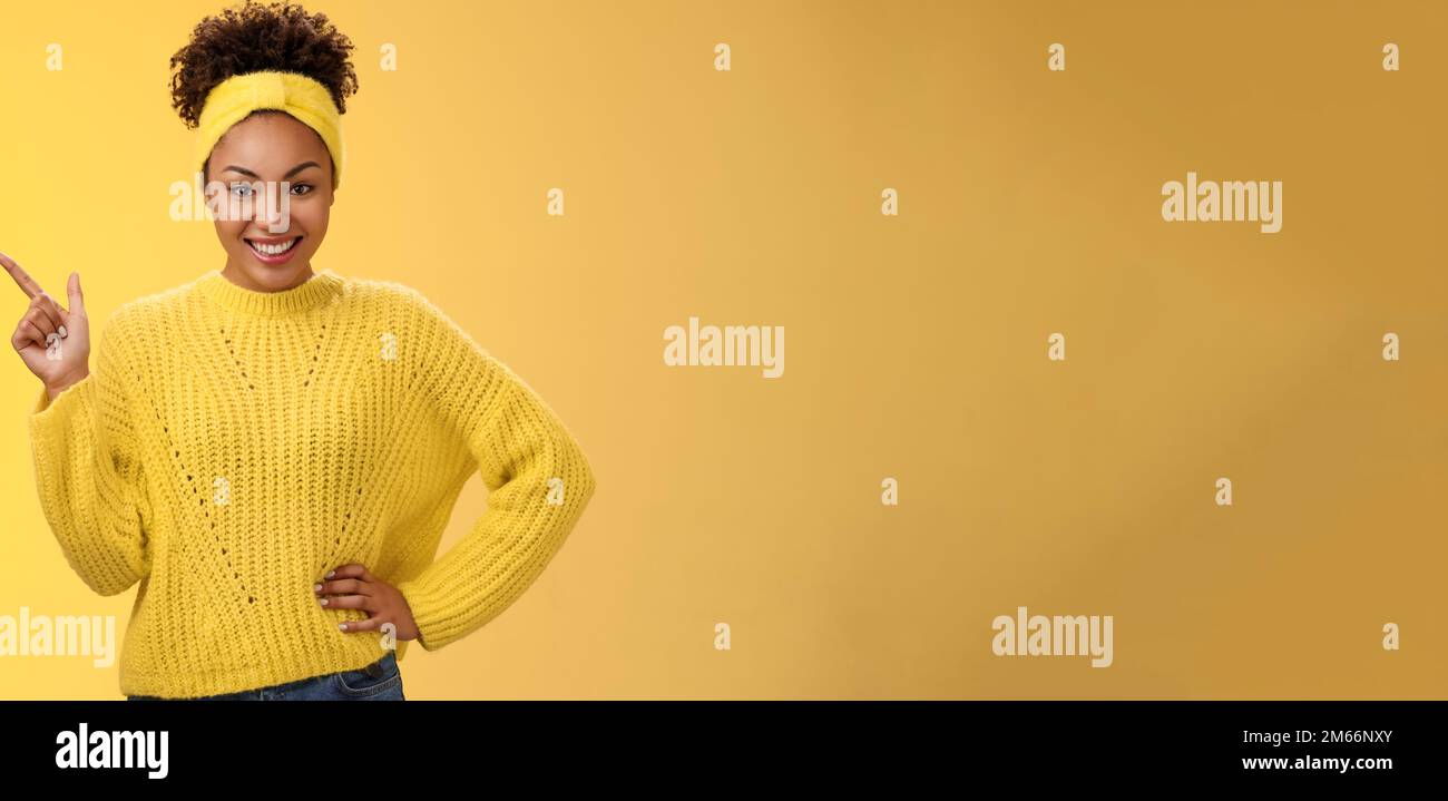 Charming sassy stylish african-american girl in sweater pointing upper ...