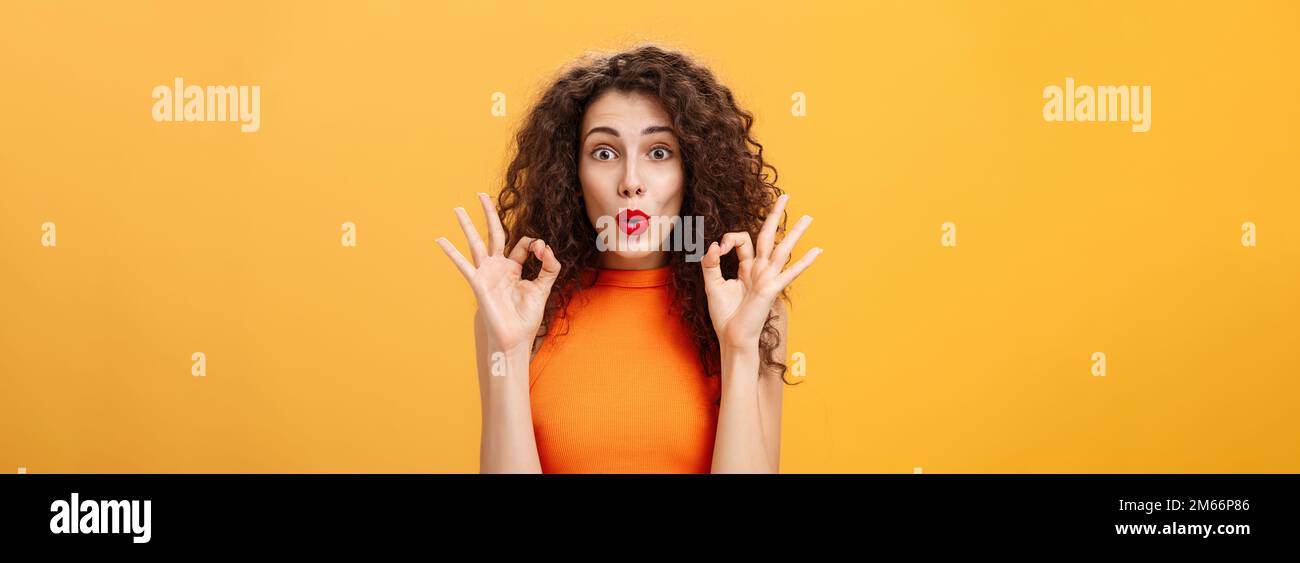 Enthusiastic charming caucasian girl with curly hairstyle in red ...