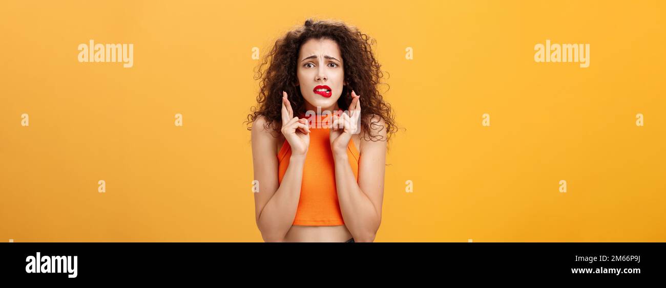 Worried and anxious silly caucasian female with curly hair in red ...