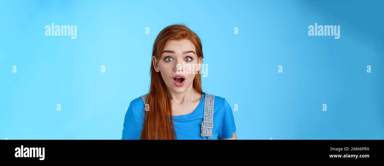Shocked redhead girl react omg shook, drop jaw speechless, stare ...