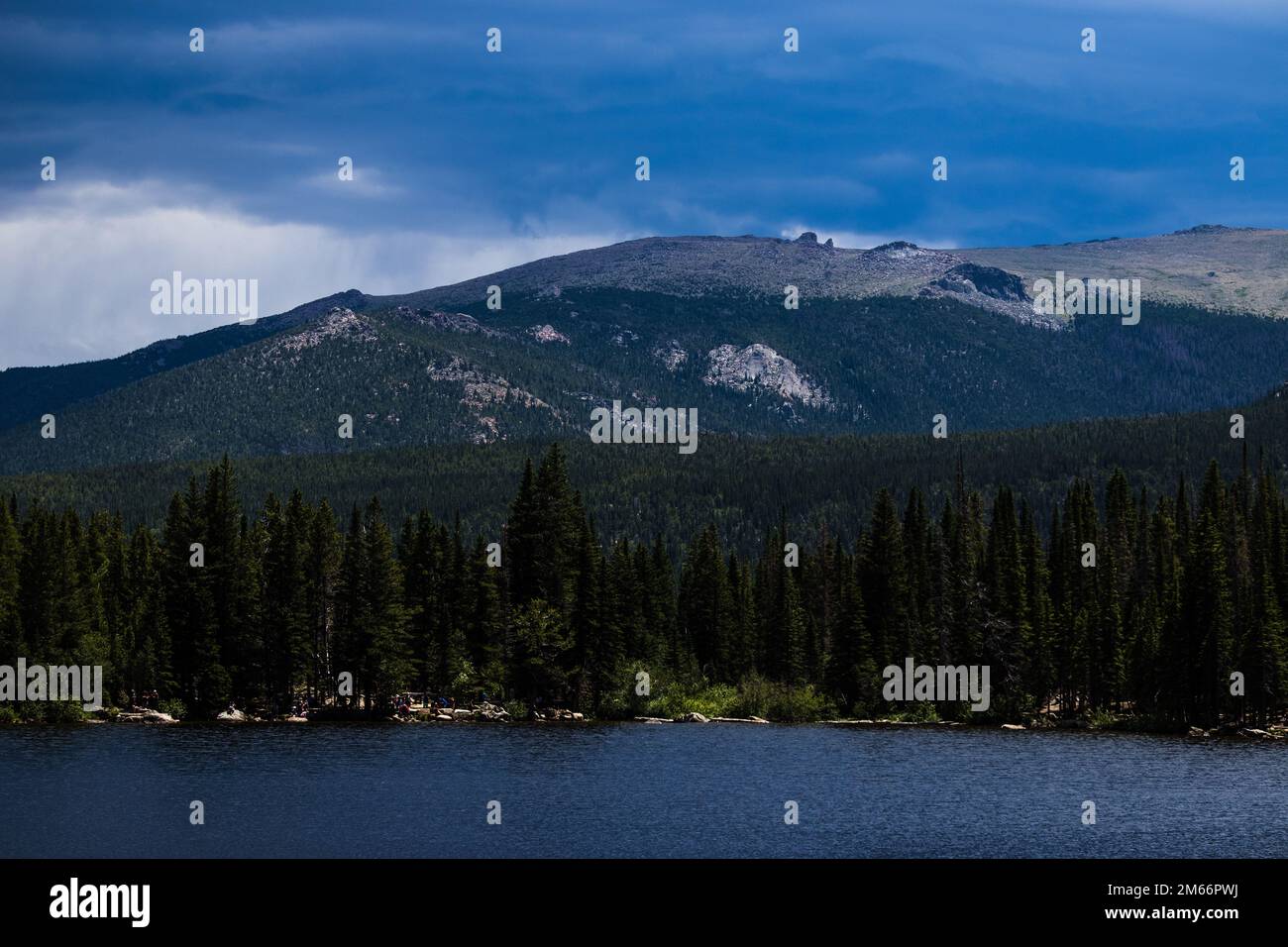Bear Lake wooded shoreline with the Rocky Mountains in the distance ...