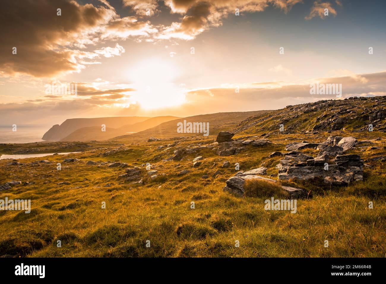 Midnight sun rising over Knivskjellodden, a trail in the tundra towards ...