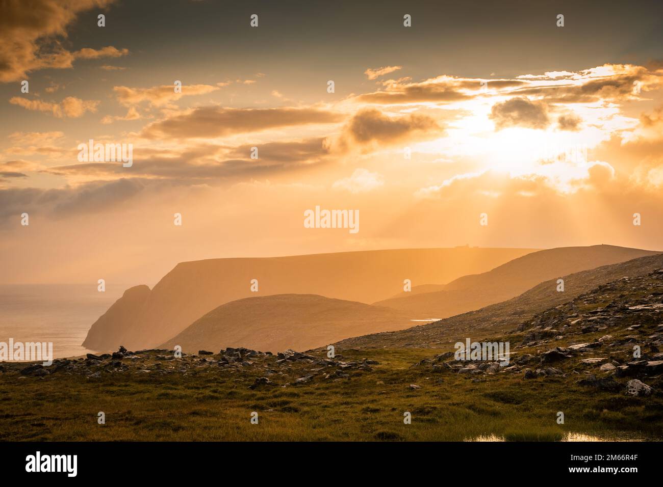 Midnight sun rising over Knivskjellodden, a trail in the tundra towards ...