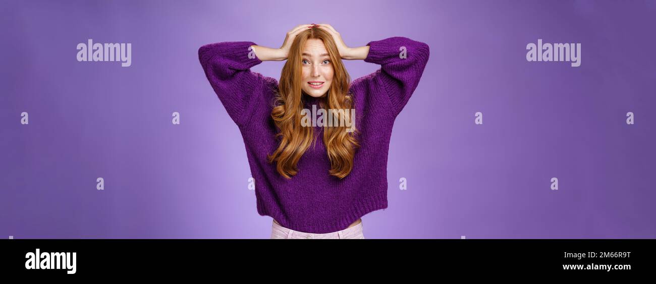 Cute european redhead 20s woman acting nervous, holding hands on head ...