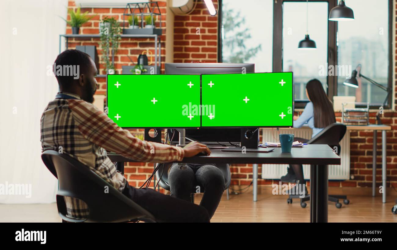 Office worker looking at greenscreen template on computer, working with ...