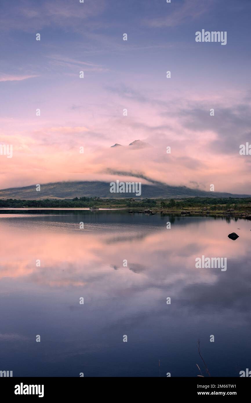 Spectacular reflection of the mountains on a lake with mist under the ...