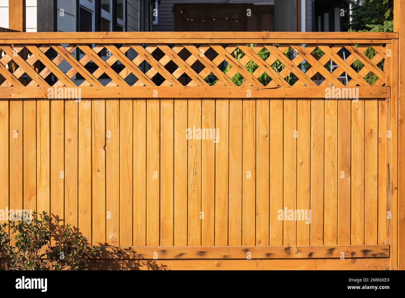 Nice wooden fence around house. Wooden fence with green lawn. Street ...