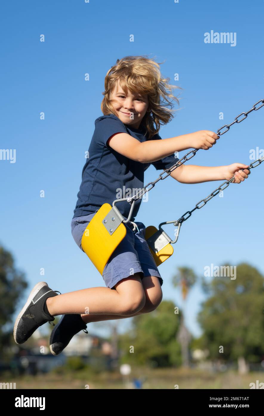 Swinging on playground. Child boy on swing. Little kid swinging on playground. Happy cute ...