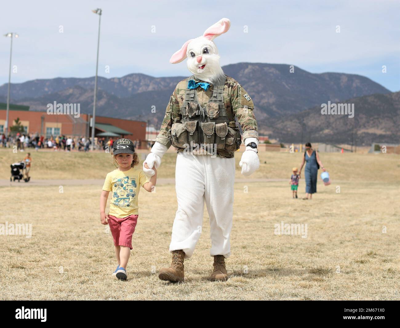 The Easter Bunny escorts a child during an Easter Egg Hunt event hosted ...