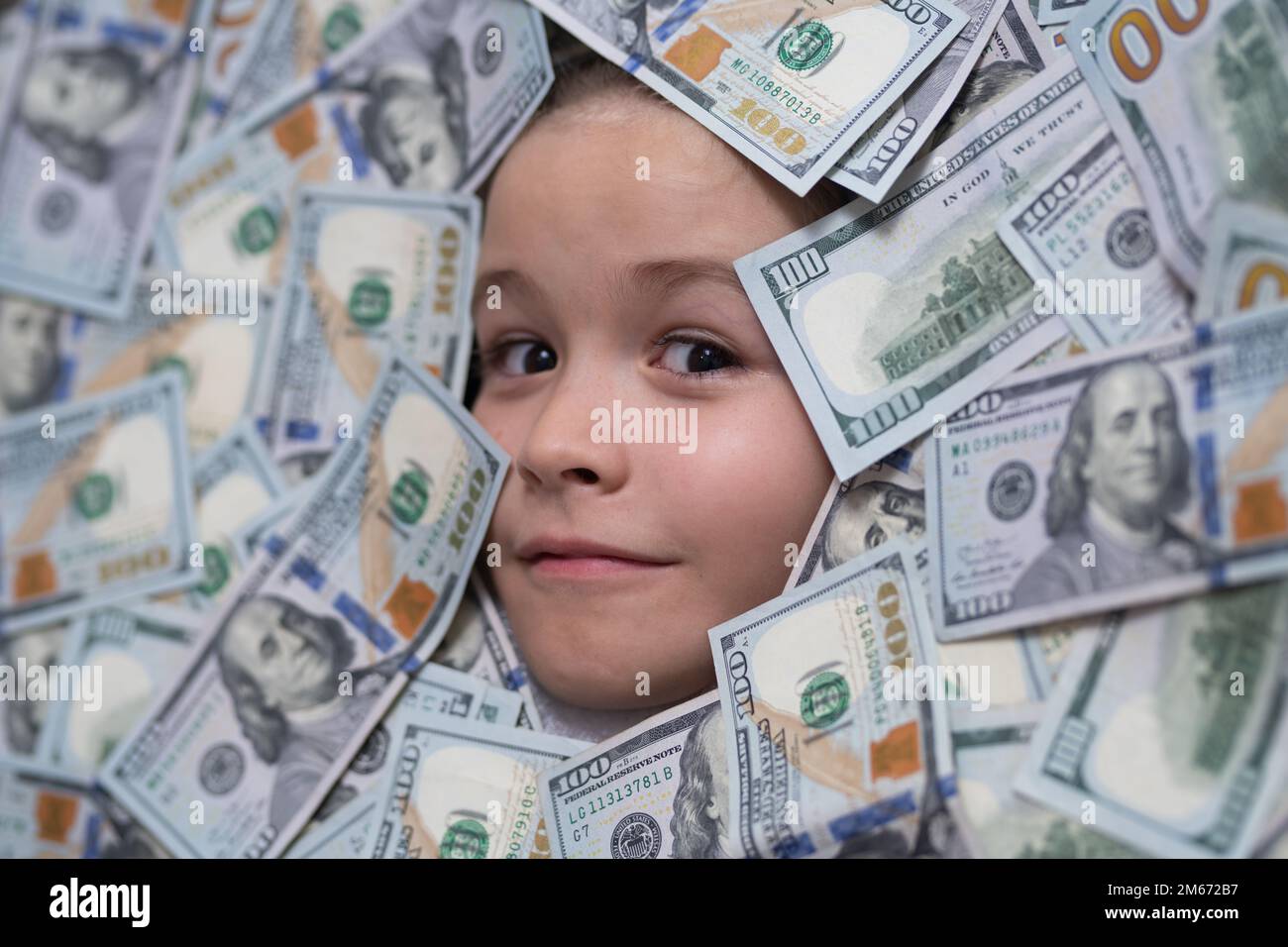 Kids how to be rich. Child with dollar bills near face. Money banknotes ...