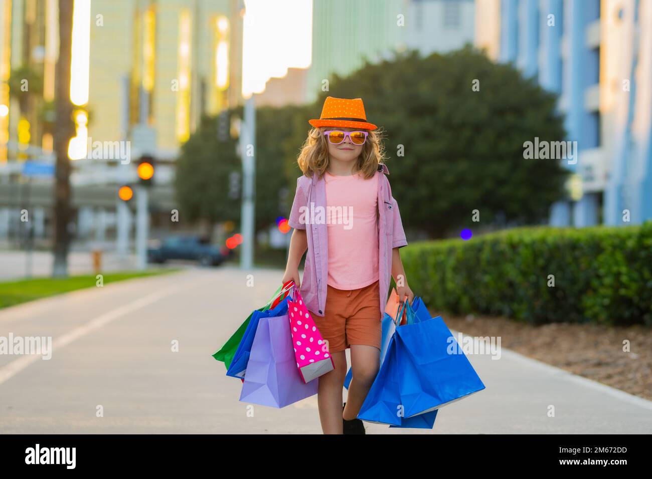 Discounts and sales. Happy kid boy with shopping bags. Little child on ...
