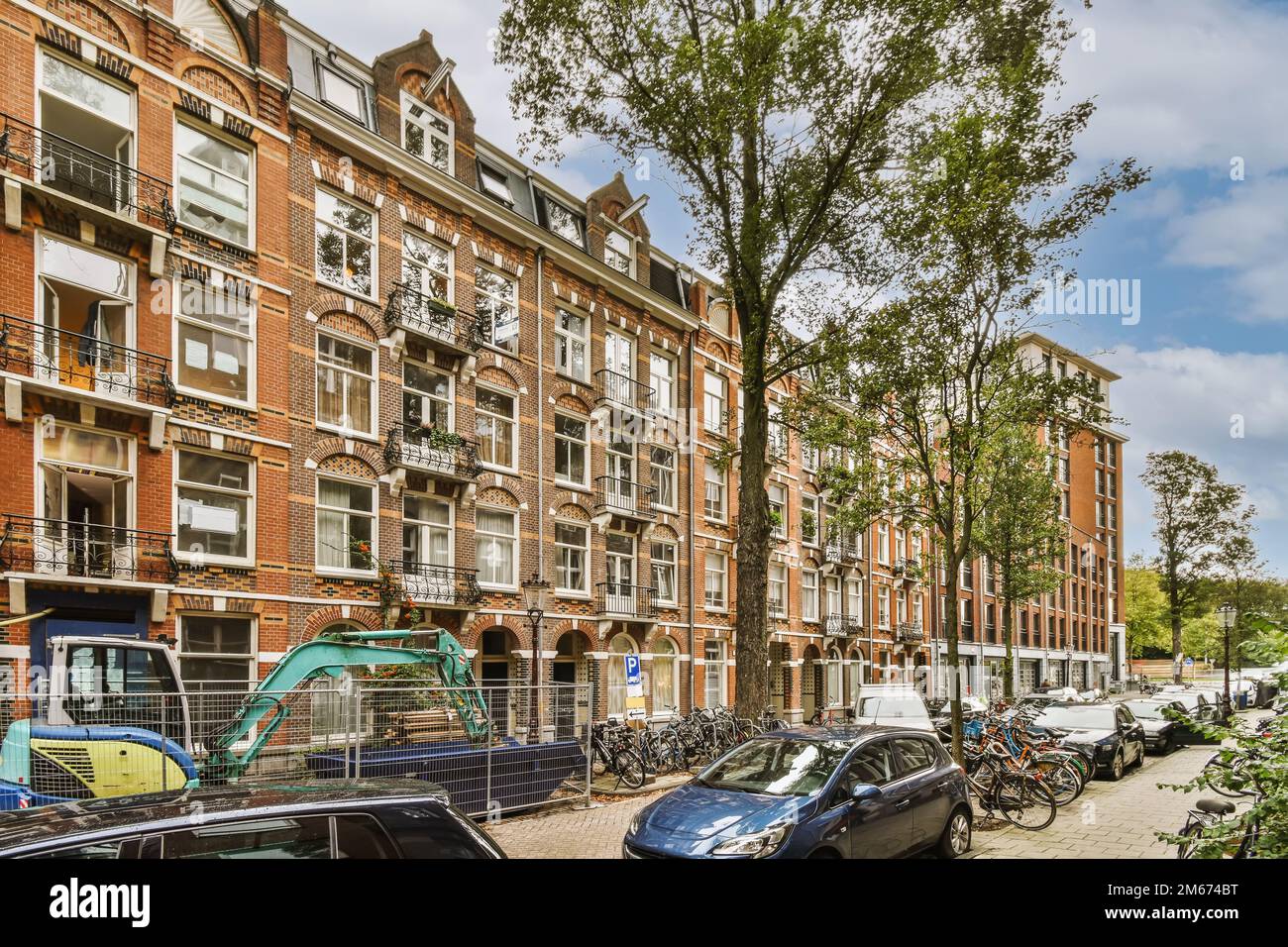 some cars parked on the side of a street in an urban area, with many ...