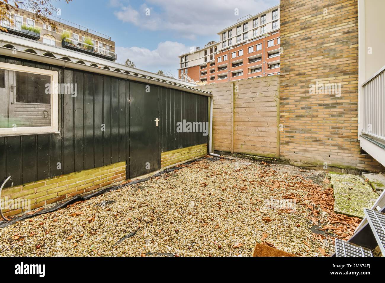an outside area with some leaves on the ground and brick buildings in ...