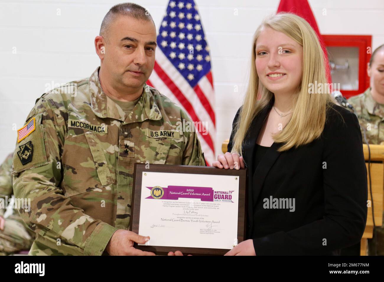 Lily Palfrey, right, daughter of 1st Sgt. Frank Palfrey, receives the ...