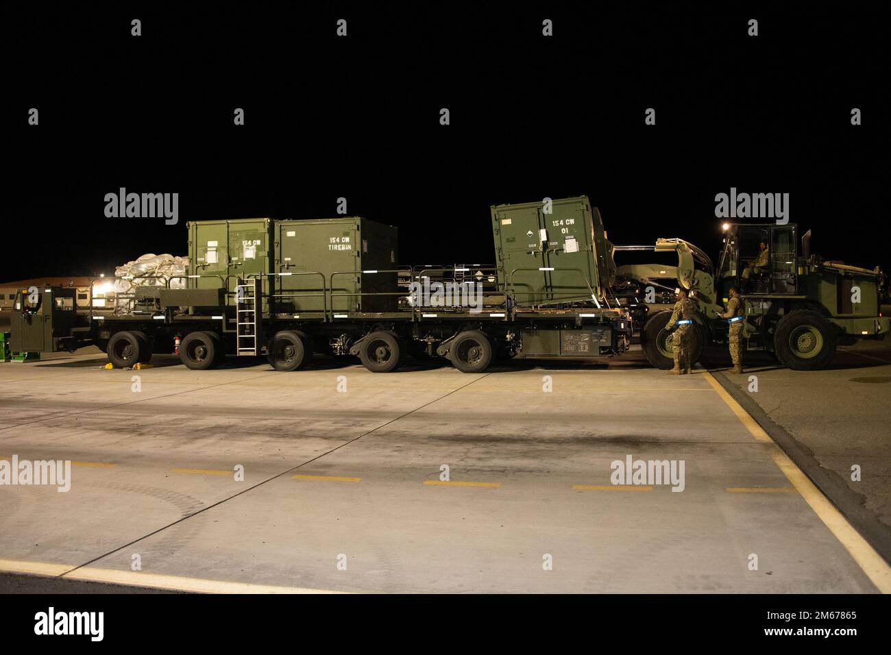 U.S. Airmen assigned to the 60th Aerial Port Squadron load a Tunner 60K ...