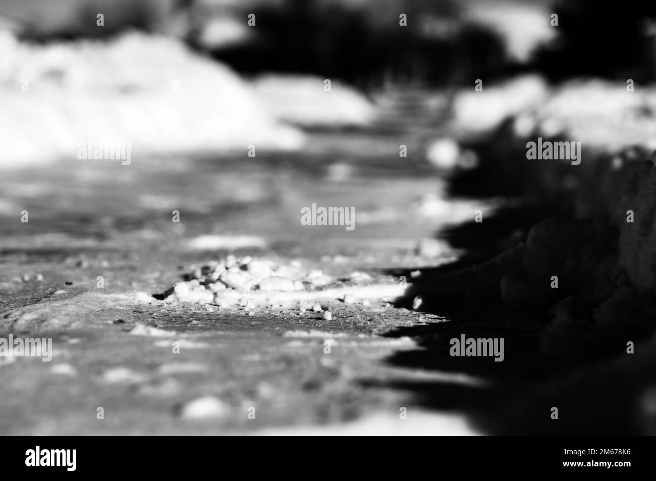 Selective focus ground level view of snow blown sidewalk section with ...