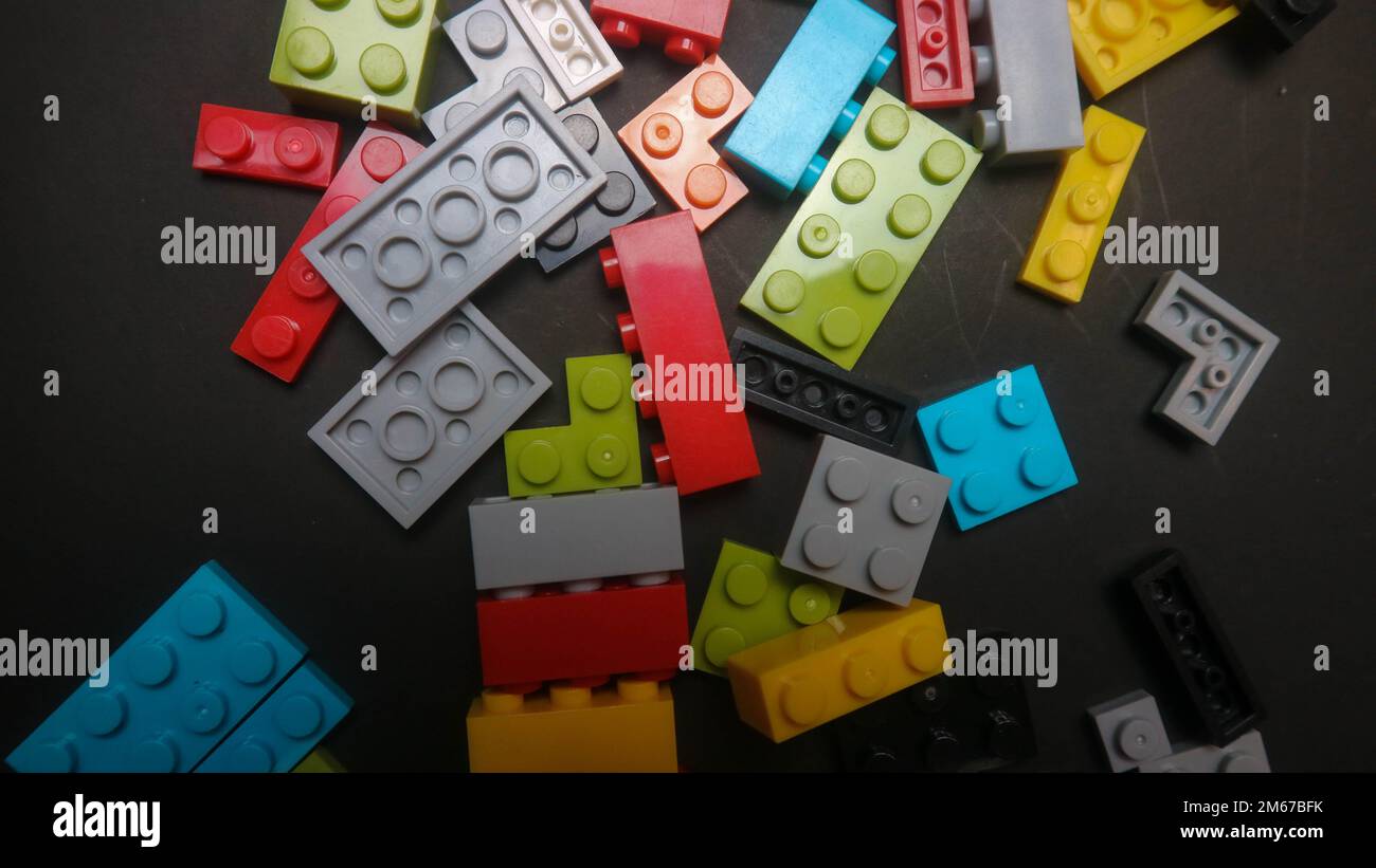 Plastic toy blocks on black background Stock Photo - Alamy
