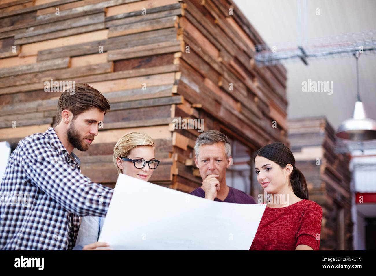 Giving his input. A group of colleagues looking over some plans Stock ...