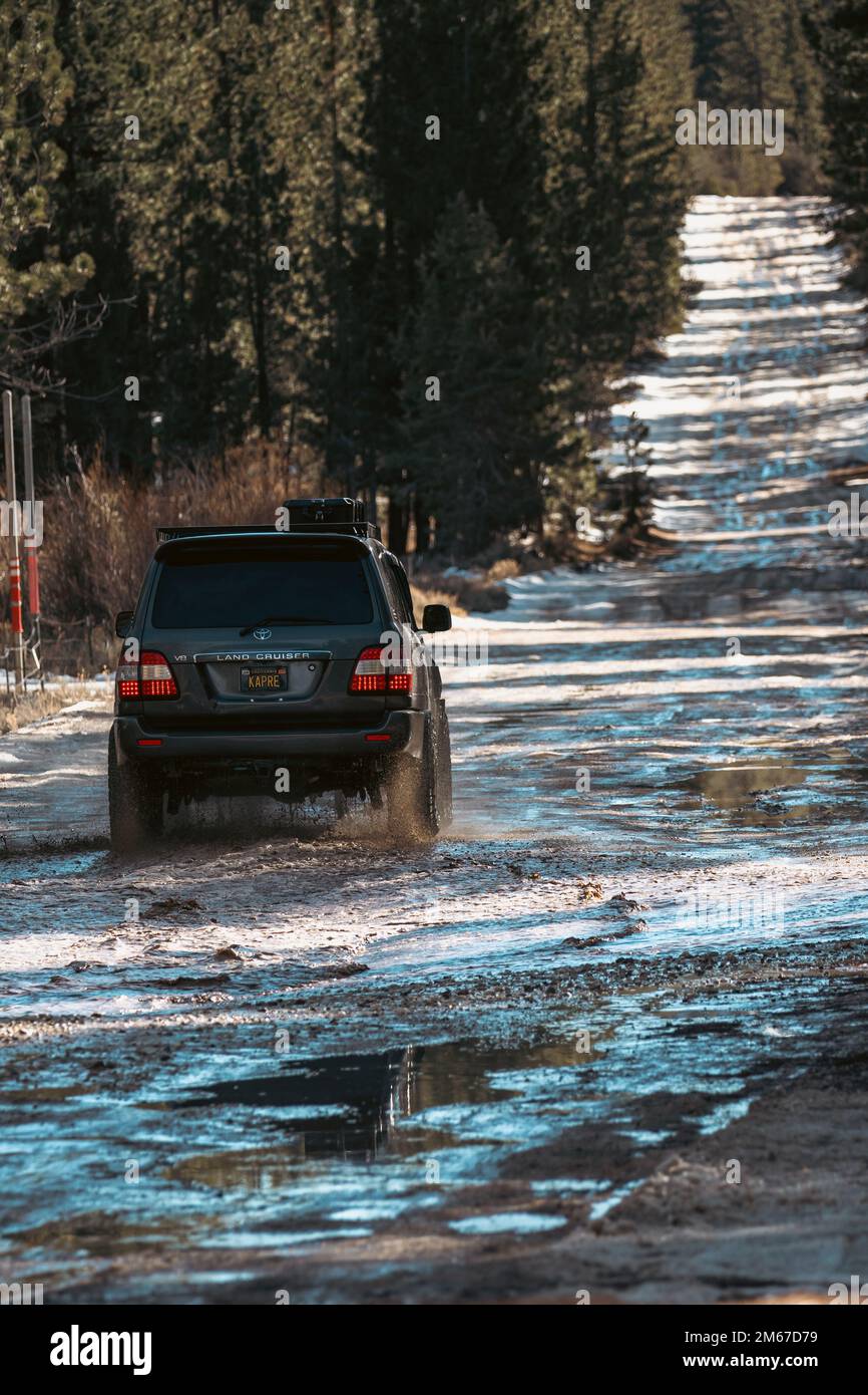 Rear Angle view of Off Road Overland Land Cruiser SUV crossing water on ...