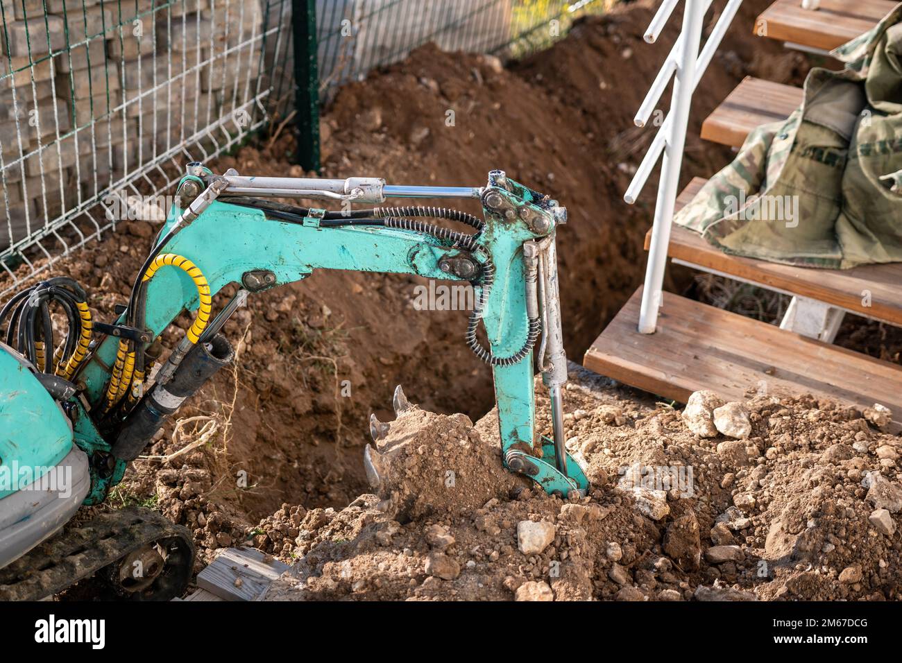 Mini excavator digs a trench to lay pipes. Close up of an excavator ...